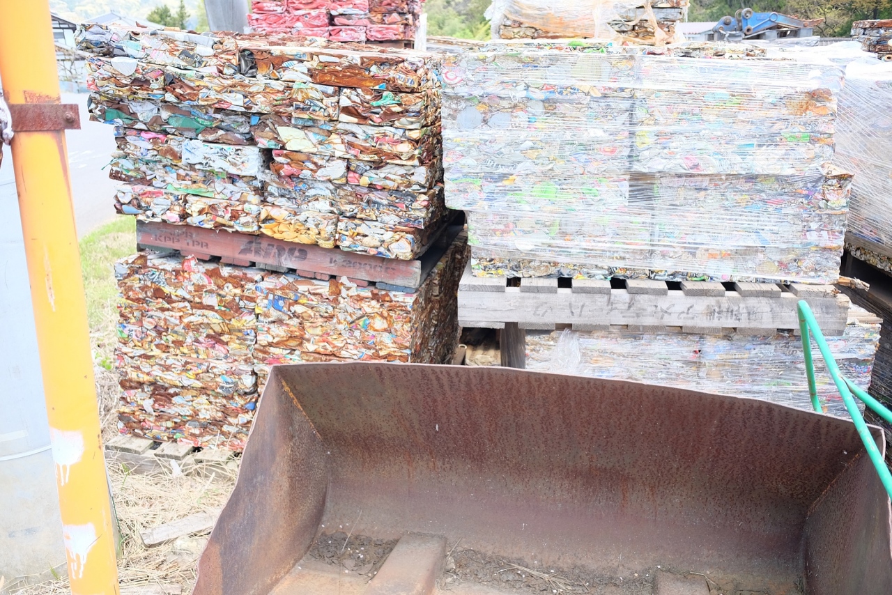François on pallets of crushed cans · Rob Nugen